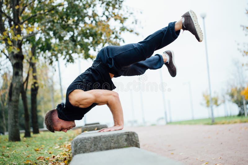 Male Runner Doing Exercise, Workout in the Fall Park. Push Ups with ...
