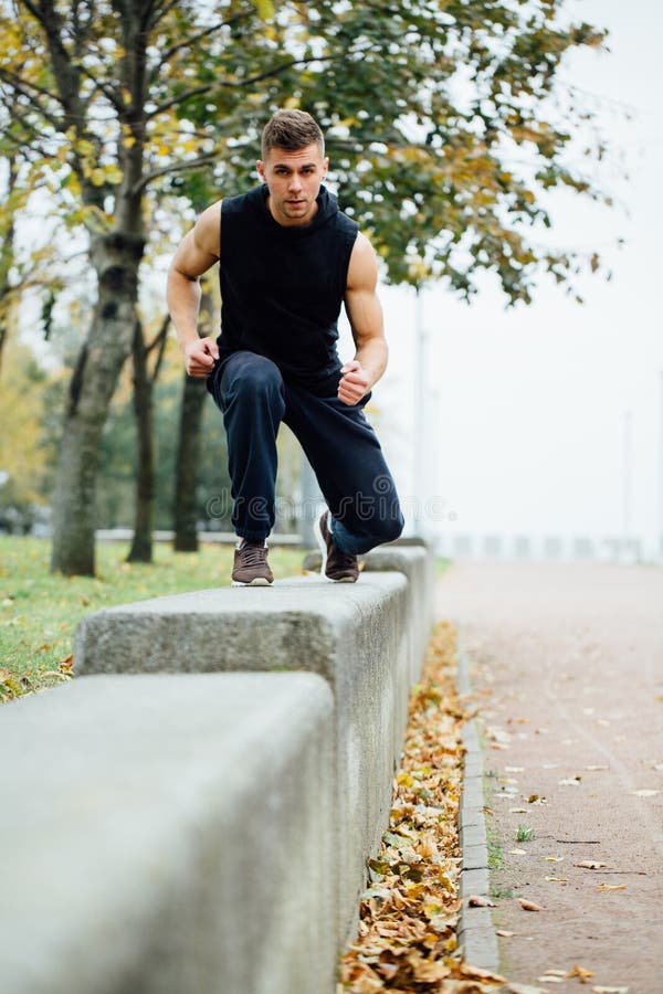 Male Runner Doing Exercise, Workout in the Fall Park. Push Ups with ...