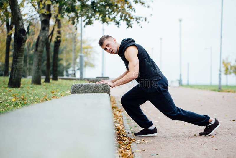 Male Runner Doing Exercise, Workout in the Fall Park. Push Ups with ...