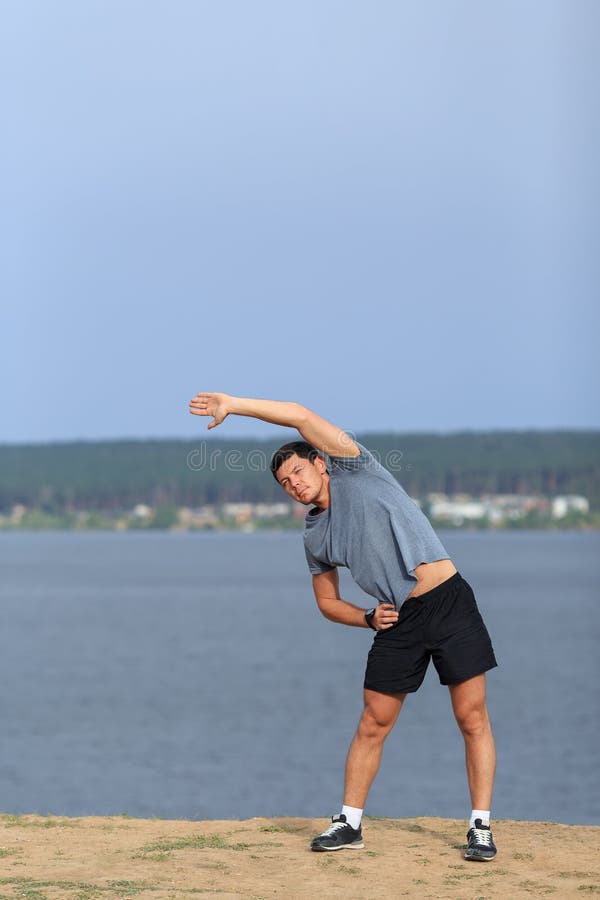 Male Runner Doing Stretching Exercise, Preparing for Morning Workout in ...