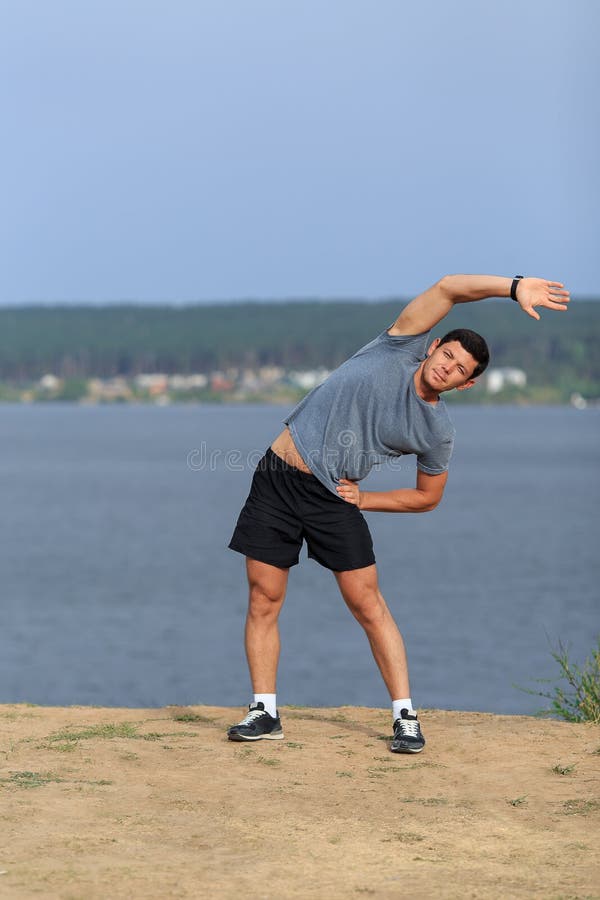 Male Runner Doing Stretching Exercise, Preparing for Morning Workout in ...