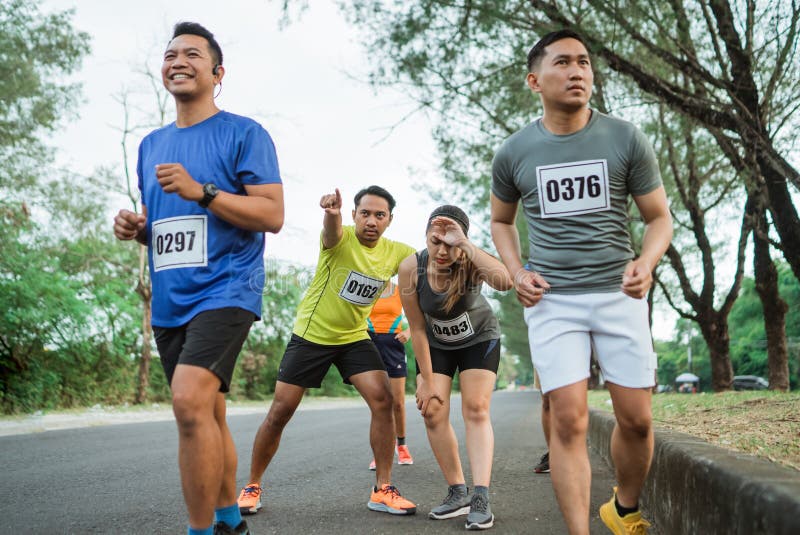 Male Runner Helping Ill Female Participant Stock Photo - Image of ...