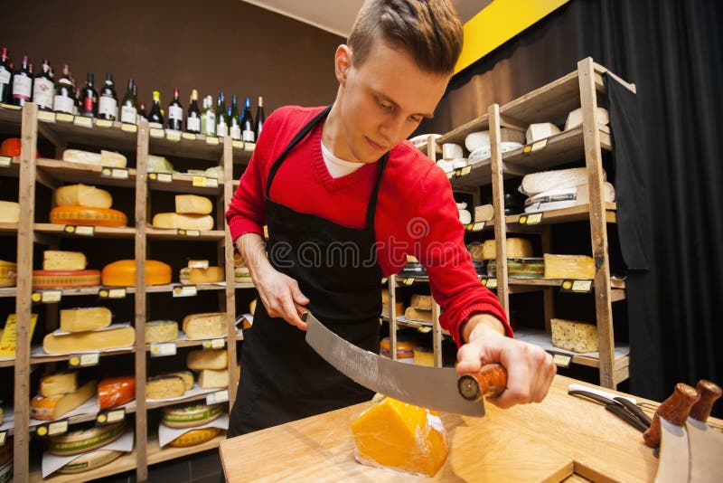 Male Salesperson Cutting Cheese in Store Stock Image - Image of holding ...