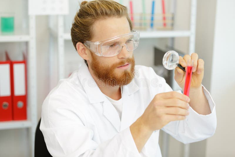 Male Scientist Analysing Something through Magnifying Glass Stock Photo ...