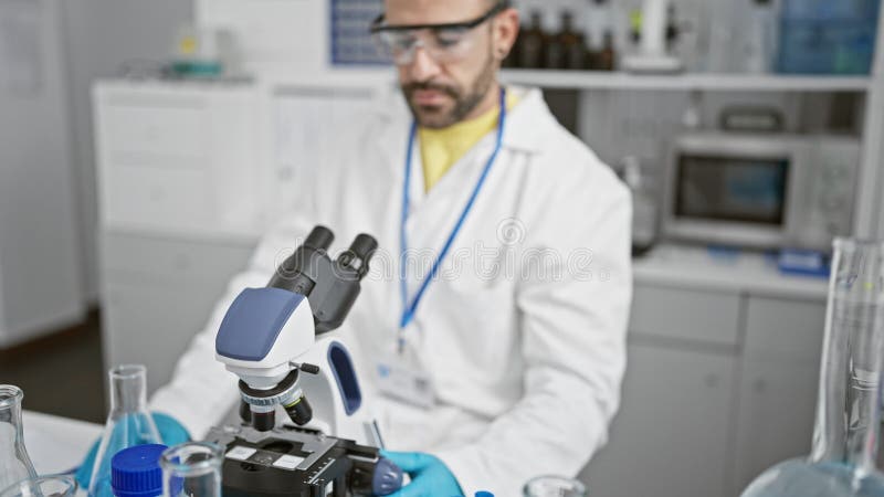 A Male Scientist with Glasses and Beard Conducts Research Using a ...