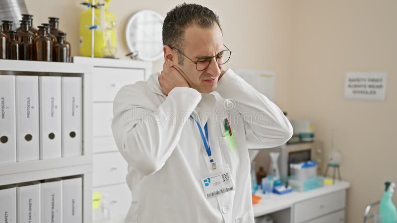 A Male Scientist in Lab Coat Experiencing Neck Pain in a Laboratory ...