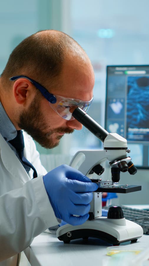 Male Scientist Looking Under Microscope in Medical Development ...