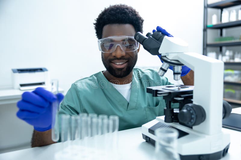 Male Scientist Looking Under Microscope Using Test Tubes Stock Photos ...
