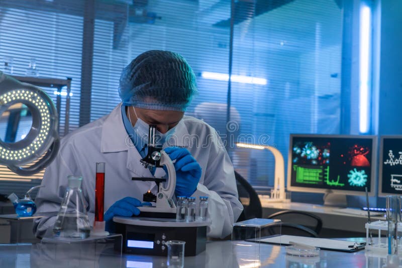 Male Scientist Sitting in a Research Lab with Test Tubes and Flasks. a ...
