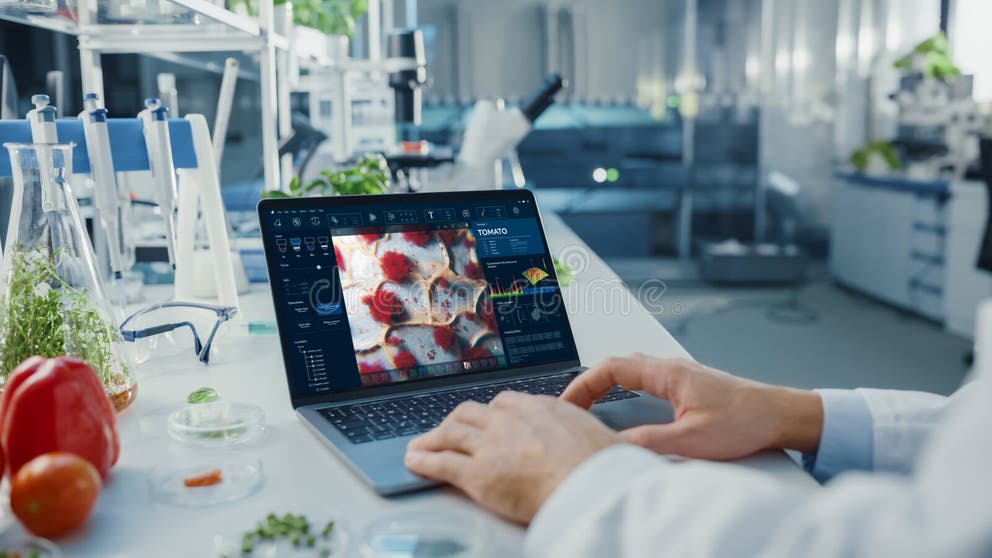 Male Scientist Working on a Laptop Computer with Display Showing Gene ...
