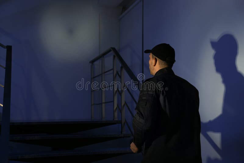 Male Security Guard with Flashlight Going Up Stairs Stock Photo - Image ...