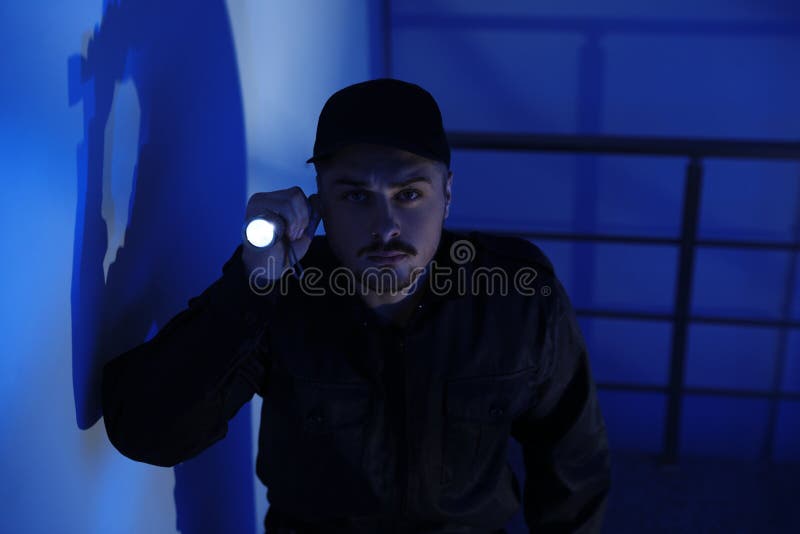 Male Security Guard with Flashlight in Room Stock Photo - Image of ...