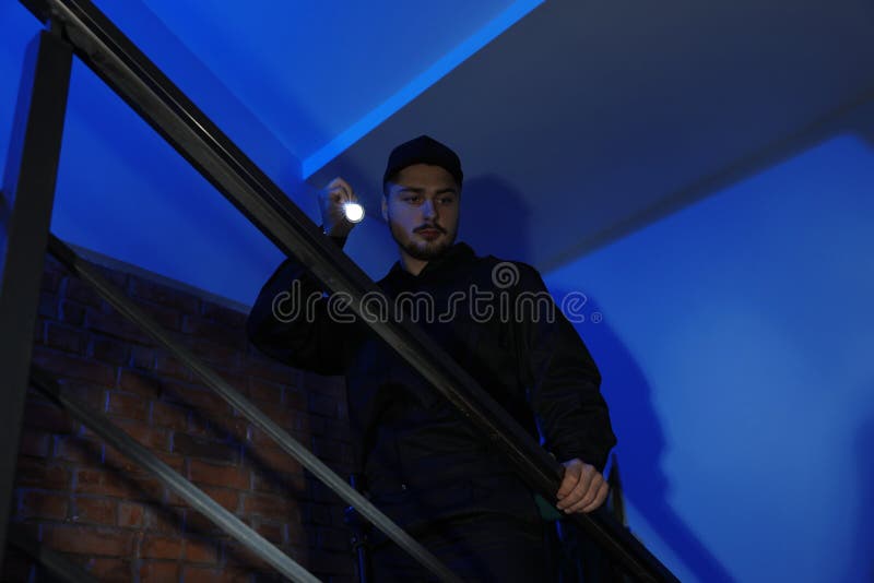 Male Security Guard with Flashlight on Stairs Stock Photo - Image of ...