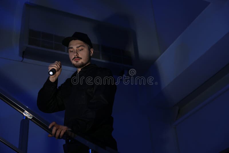 Male Security Guard With Flashlight On Stairs Stock Photo - Image of ...