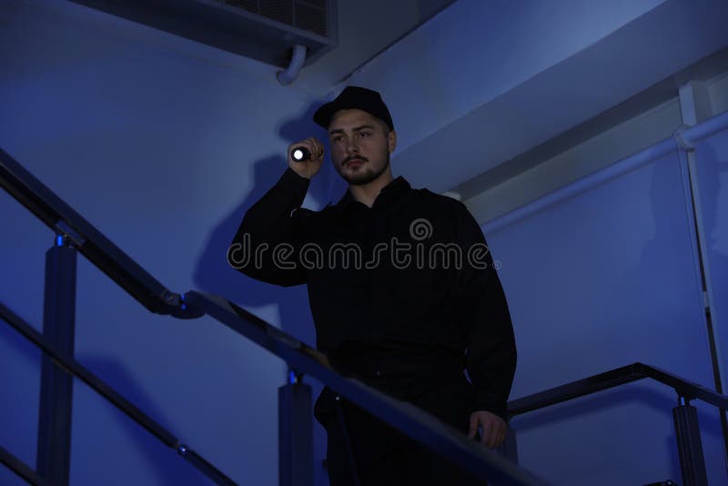 Male Security Guard with Flashlight Going Up Stairs Stock Image - Image ...