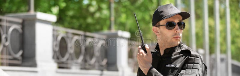 Male Security Guard Using Portable Radio Transmitter Outdoors. Banner ...