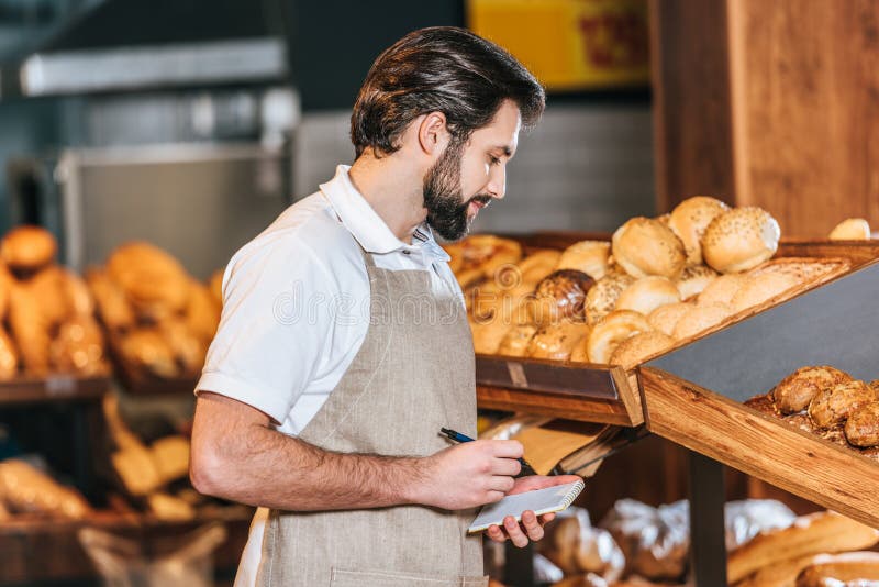 Male Shop Assistant in Apron Making Notes in Notebook Stock Image ...