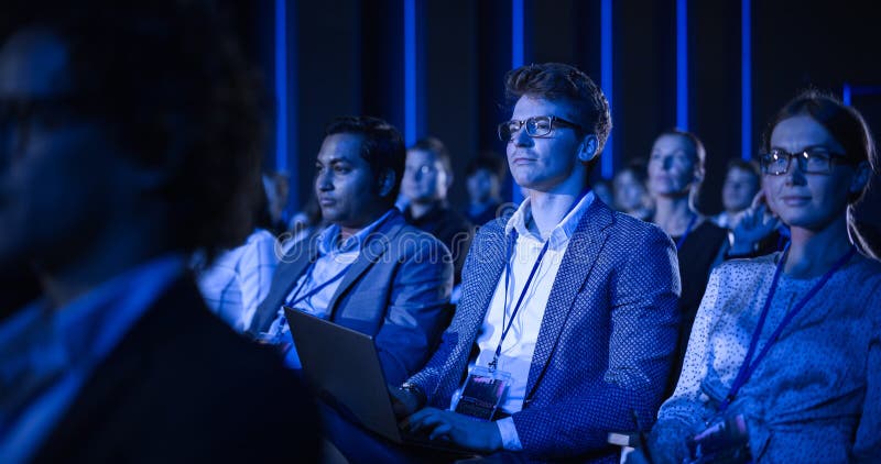 Male Sitting in a Dark Crowded Auditorium at a Tech Conference ...