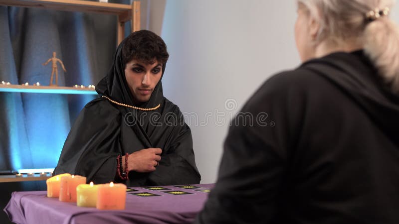 Male Sorcerer Tarot Card Reader Predicts the Future at a Tarot Session ... Male Sorcerer Tarot Card Reader Predicts the Future at a Tarot Session ...