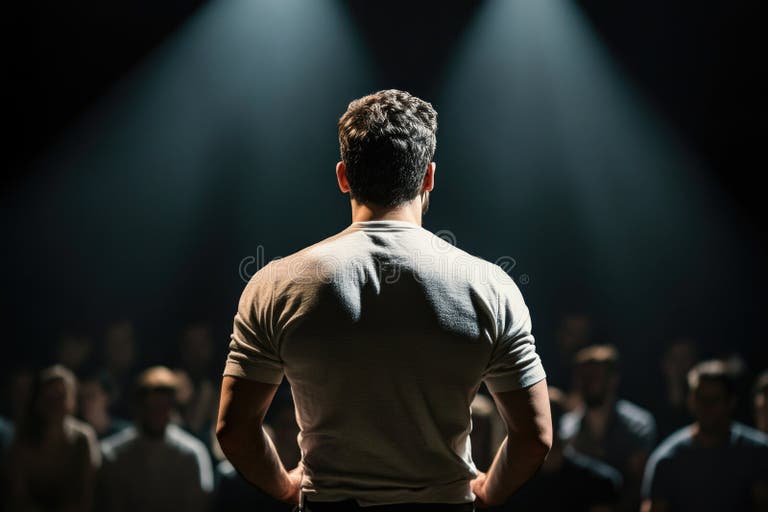 Male Speaker on Stage Under Spotlight Facing Audience Stock Photo ...