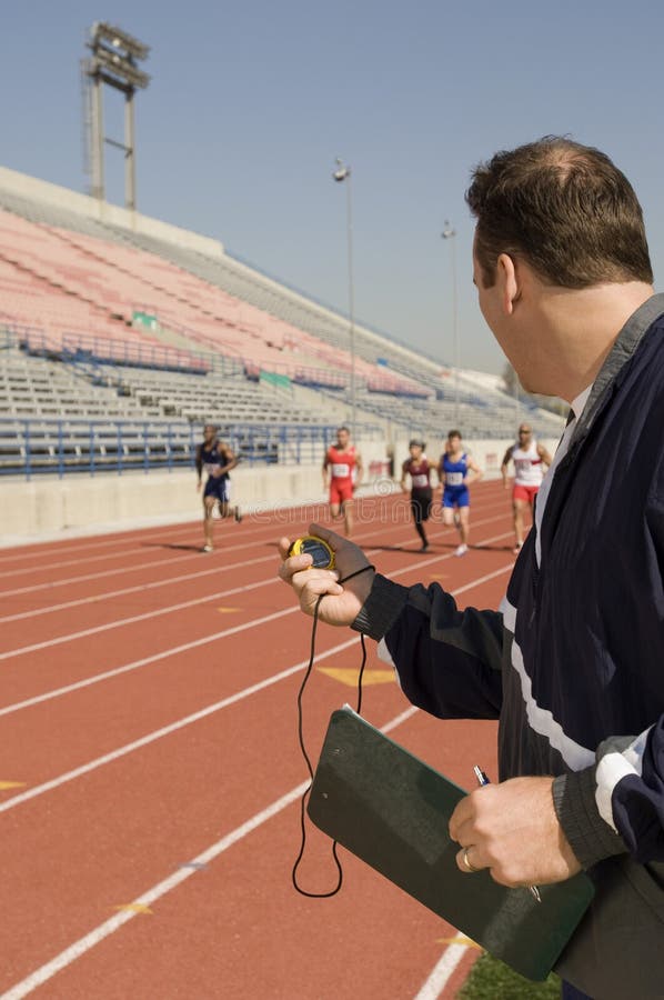 Male with Stopwatch Looking at Athletes Racing Stock Photo - Image of ...