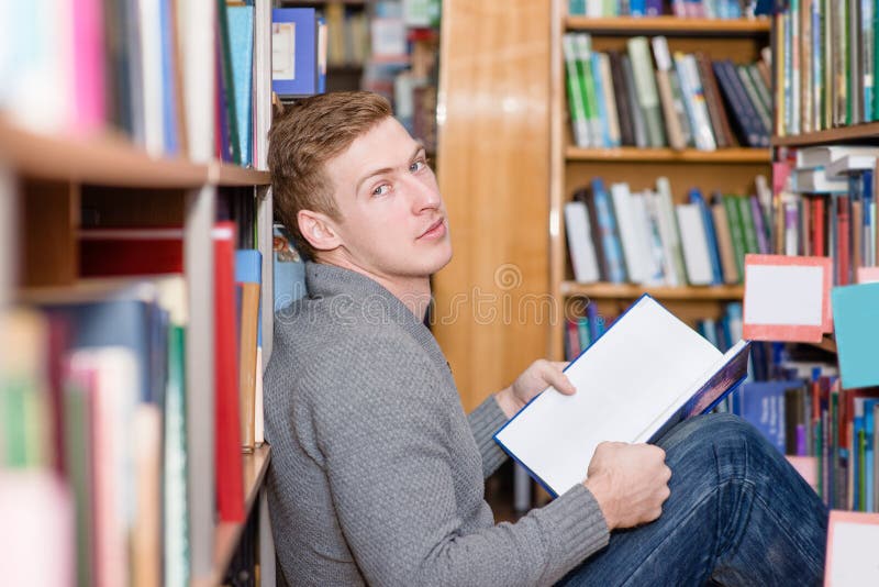Male Student with Book Sitting on Floor in Library Stock Photo - Image ...