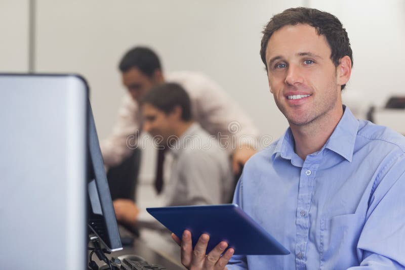 Male Student Holding a Tablet Sitting in Front of Computer Stock Image ...