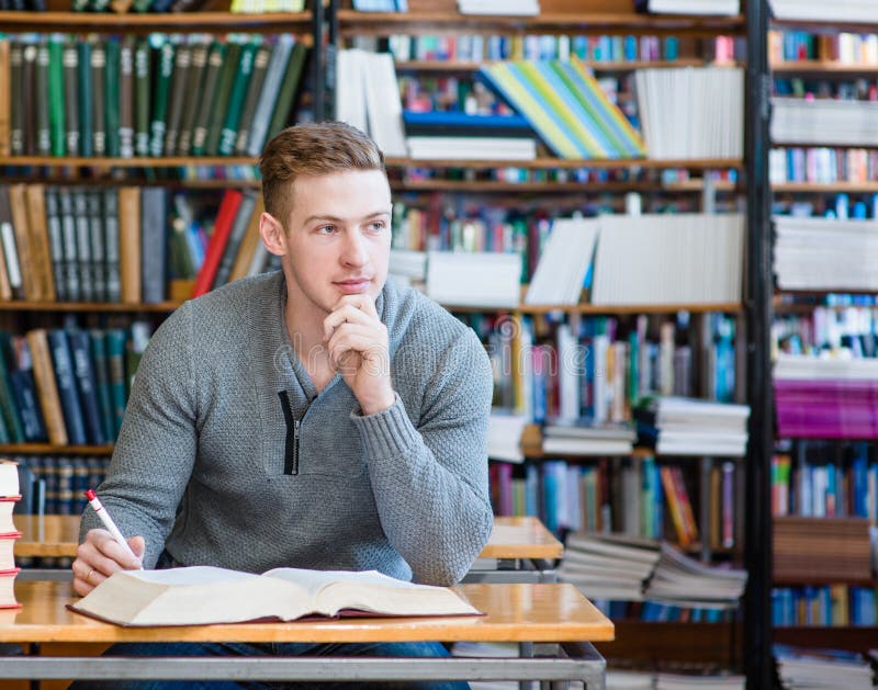 Male Student with Open Book Working in a Library Stock Photo - Image of ...
