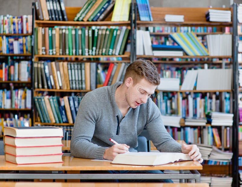 Male Student with Open Book Working in a Library Stock Image - Image of ...