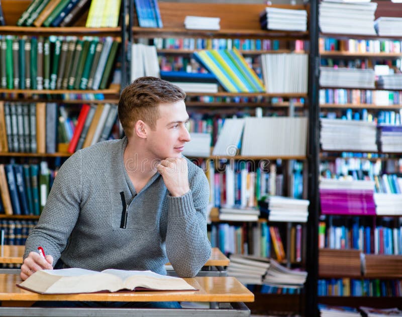 Male Student with Open Book Working in a Library Stock Photo - Image of ...
