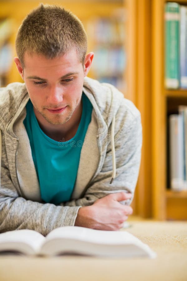 Male Student Reading Book on the College Library Floor Stock Image ...