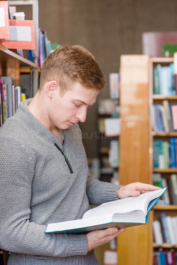 Male Student Reading Book in Library Stock Image - Image of indoor ...