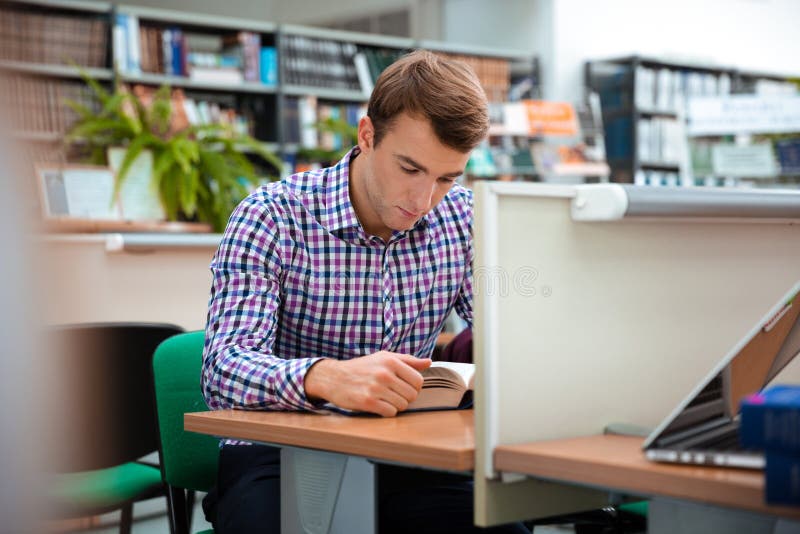Male Student Reading Book in University Library Stock Photo - Image of ...