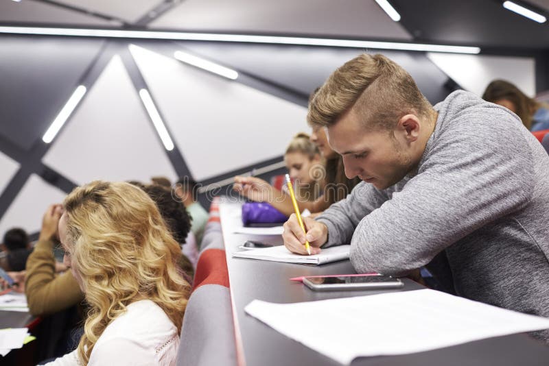 Male Student Taking Notes in a University Lecture Theatre Stock Photo ...