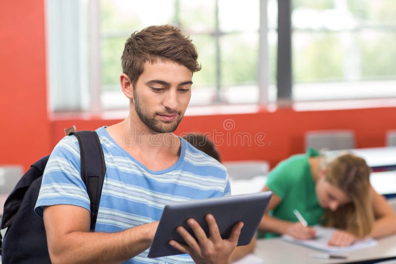 Male Student Using Digital Tablet in Classroom Stock Photo - Image of ...