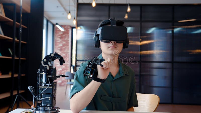 Male Student Wearing a Wireless Controller that Moves a Robotic Hand ...