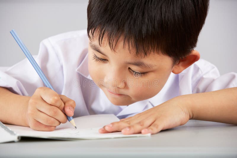 Male Student Working at Desk in Chinese School Stock Image - Image of ...