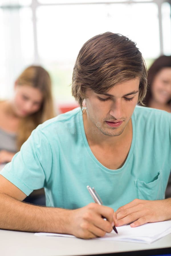 Male Student Writing Notes in Classroom Stock Image - Image of holding ...