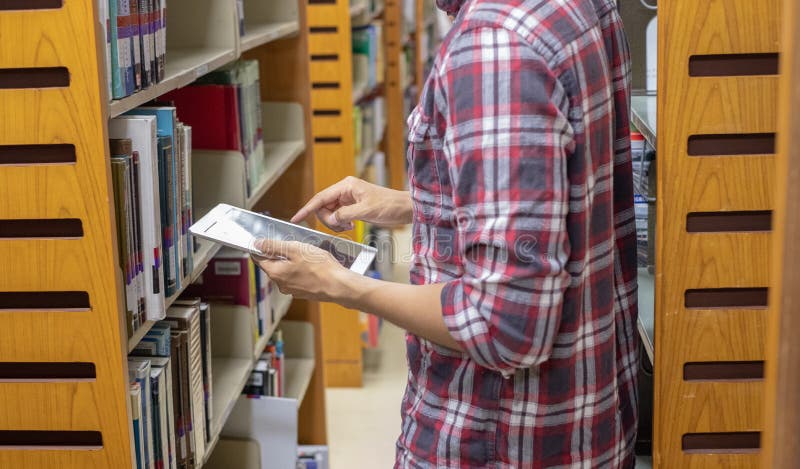 Male Students Use Technology To Find Books To Read in the Library ...