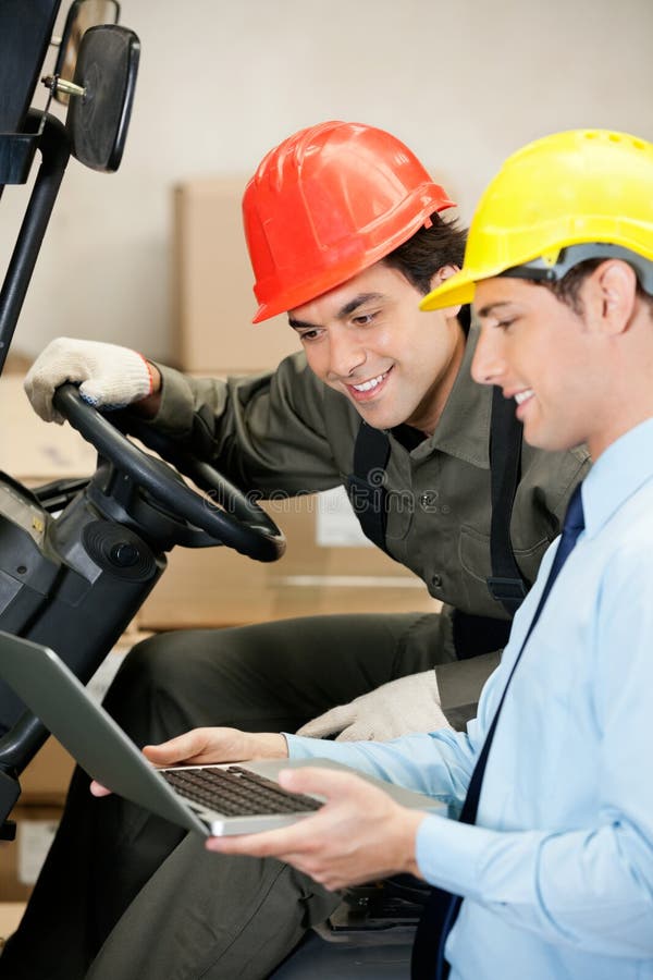 Male Supervisor and Forklift Driver Using Laptop Stock Photo - Image of ...