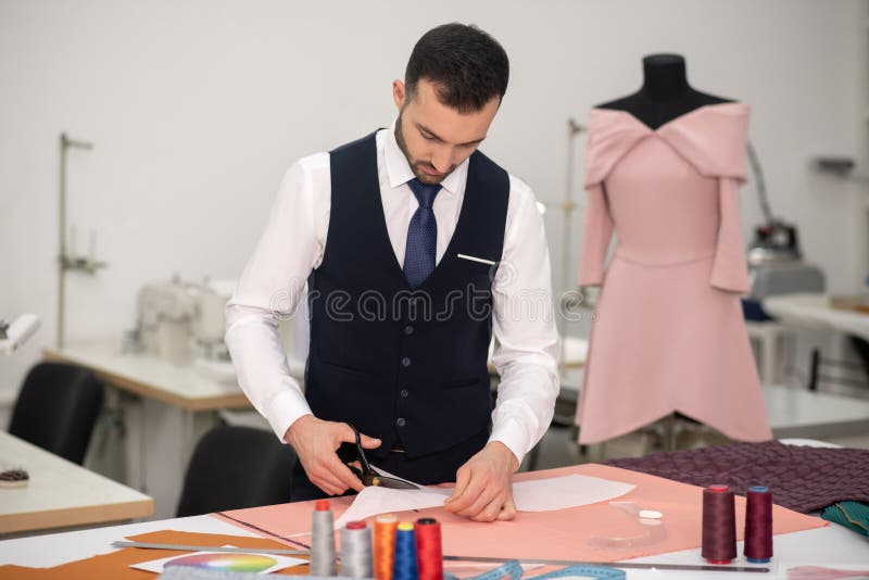 Male Tailor Standing and Cutting Out Paper Pattern Stock Image - Image ...