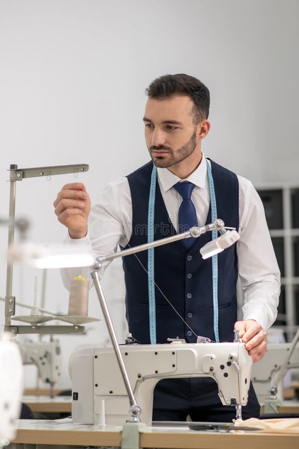Male Tailor Standing, Fixing Thread on Sewing Machine Stock Photo ...