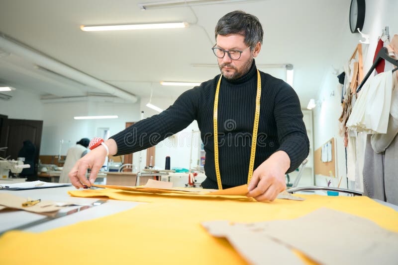 Male Tailor Stands at Cutting Table and Works with Patterns Stock Image ...