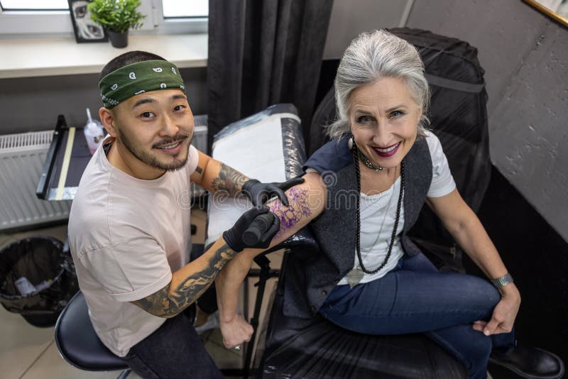 Male Tattoo Master Working in the Salon with a Customer Stock Photo ...