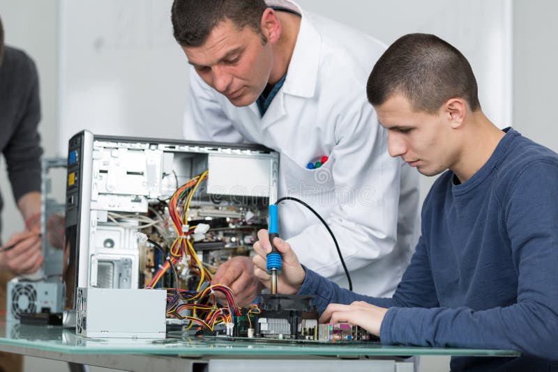 Male Teacher Assisting Young Man in Fixing Computer Stock Photo - Image ...