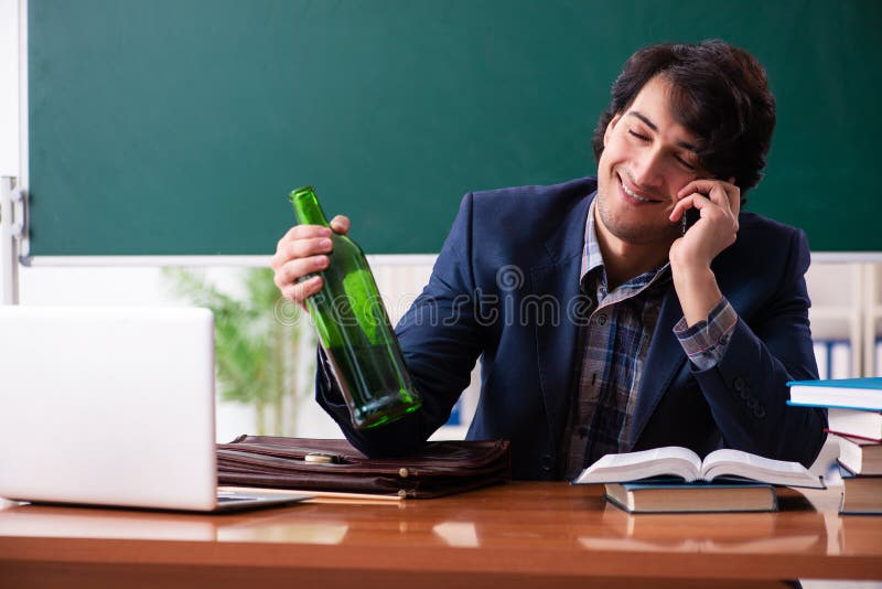 The Male Teacher Drinking in the Classroom Stock Photo - Image of book ...