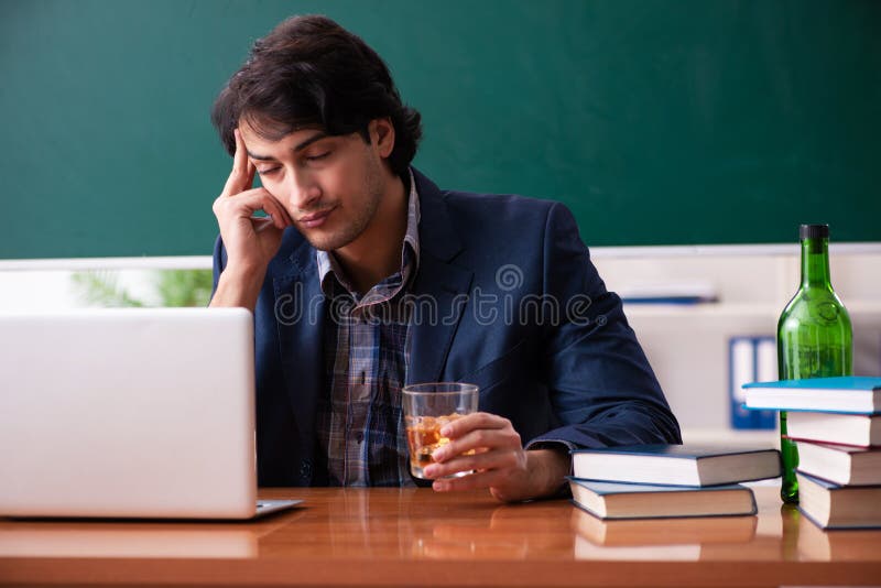 Male Teacher Drinking in the Classroom Stock Photo - Image of book ...