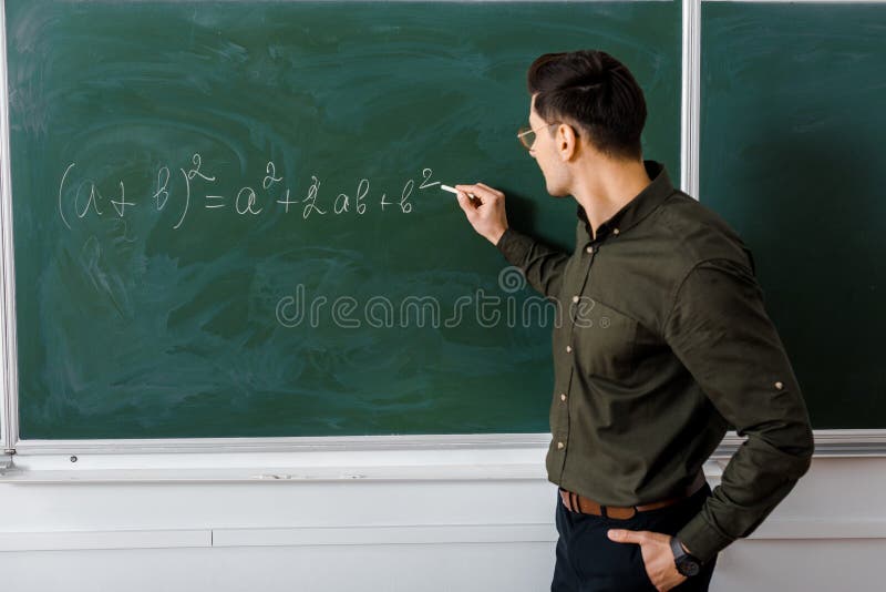 Serious Male Teacher in Formal Wear Looking at Camera and Standing Near ... Serious Male Teacher in Formal Wear Looking at Camera and Standing Near ...