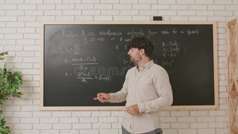 A Male Teacher Teaches a Physics Lesson and Explains a Task Written on ...