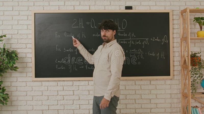 A Male Teacher is Teaching a Chemistry Class and Explaining a Task ...